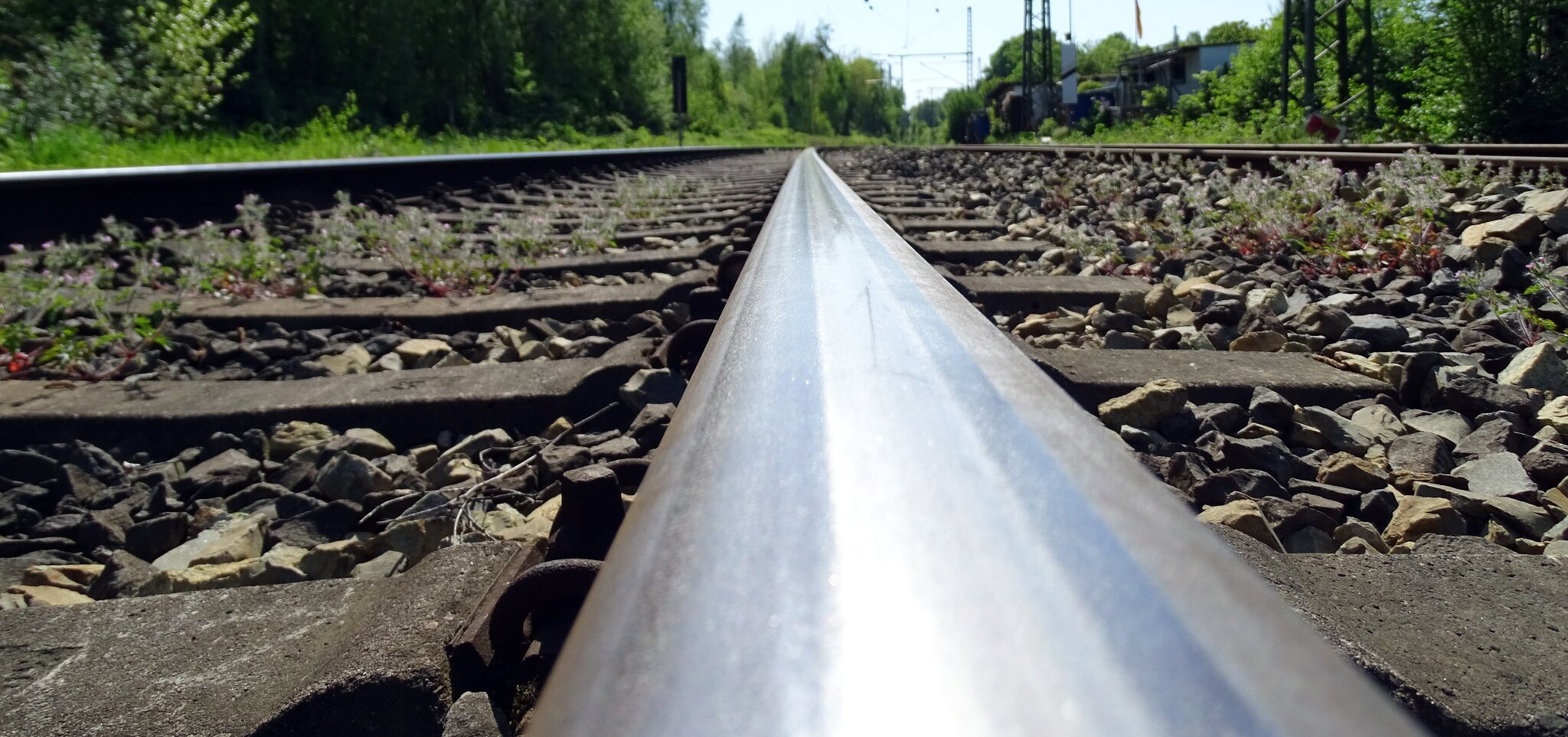 Wenn man das Ohr auf die Schiene legt, hört man den Zug schon von ...